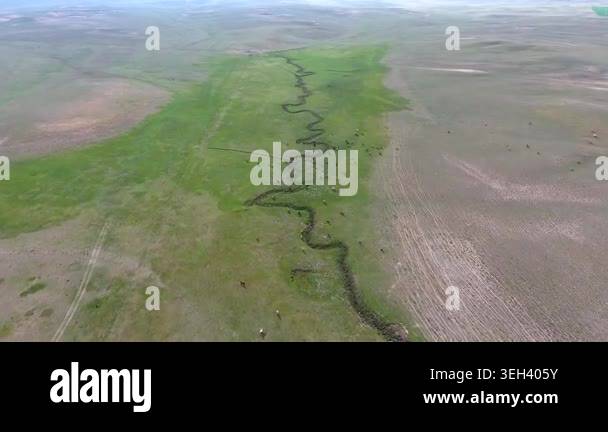River cuts through barren hills in Turkmenistan, bringing green ...