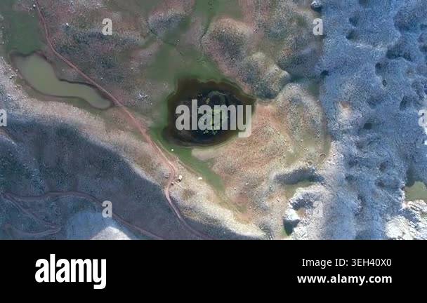 Mountain lake meets barren plateau in , with rocky slopes and treeless ...