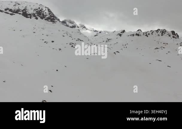 Aerial view of pristine snowy slopes across the alpine Alps mountains ...