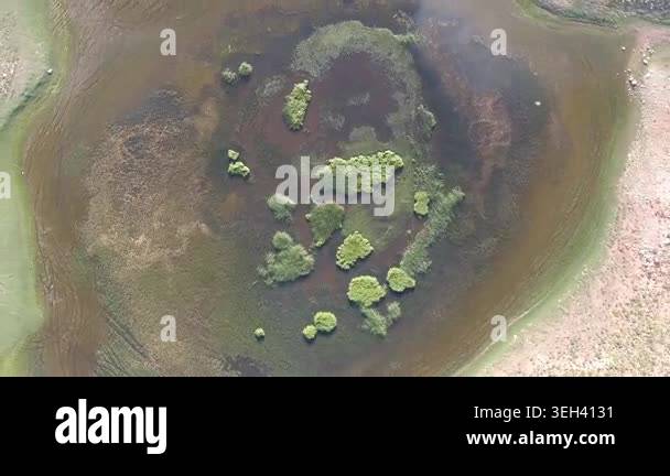 Mountain lake meets barren plateau in , with rocky slopes and treeless ...