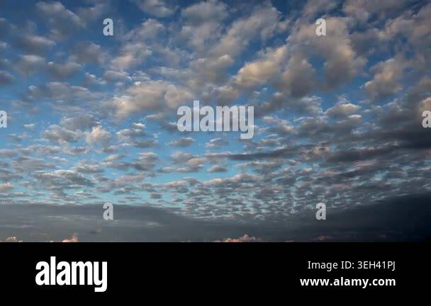 Partly cloudy altocumulus clouds in blue sky during beautiful sunset ...