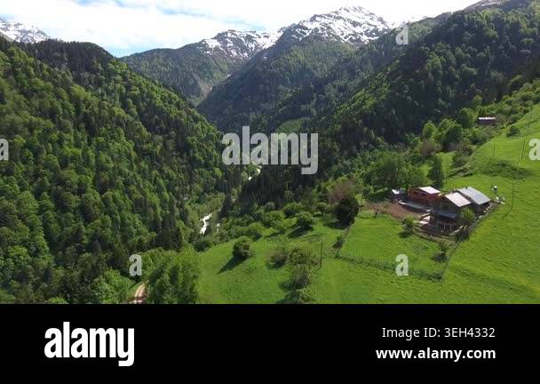Aerial view of a mountain chalet in a grassy forest clearing among the ...