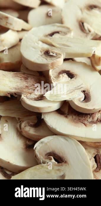 Vertical video close-up of slicing fresh, raw white champignon ...