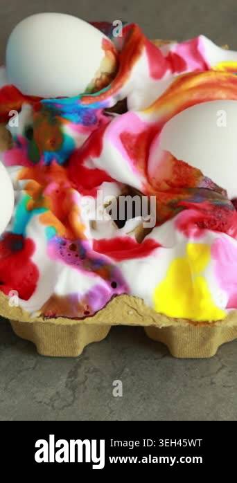 Vertical video close-up of a child's hands decorating Easter eggs using ...