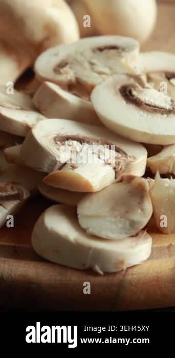 Vertical video close-up of slicing fresh, raw white champignon ...