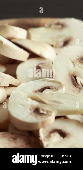 Vertical video close-up of slicing fresh, raw white champignon ...