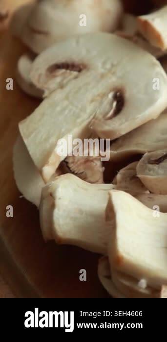Vertical video close-up of slicing fresh, raw white champignon ...