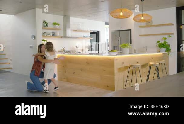 Diverse family mom entering kitchen with food child running and hugging ...