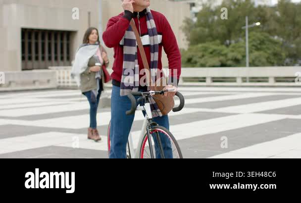 Upon getting call, adult white male stopping bicycle on plaza raising ...