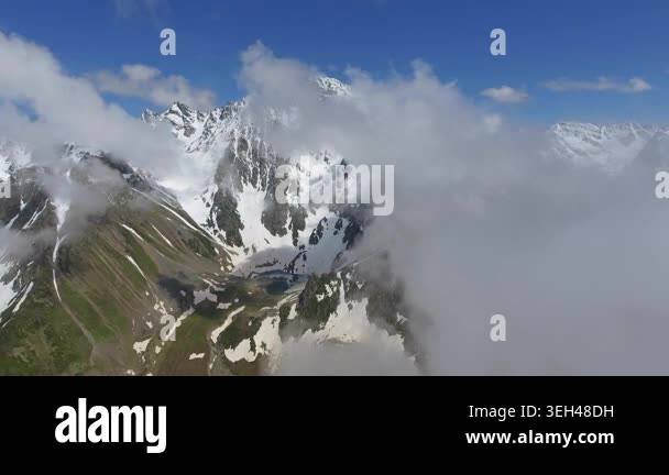 Aerial Alps Europe alpine lake below snowy peaks creates a pristine ...