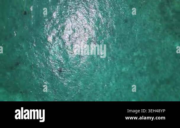 Drone camera flying over a pristine turquoise sea and revealing a ...