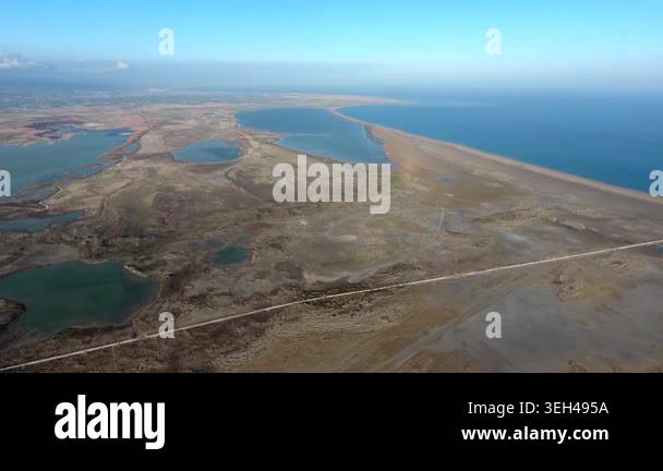 Aerial view of long thin sand tombolo separating turquoise sea and calm ...
