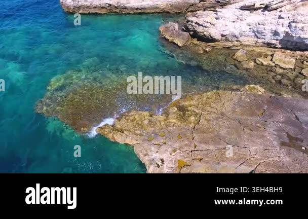 Aerial overhead view of rocky shallows and transparent sea along ...