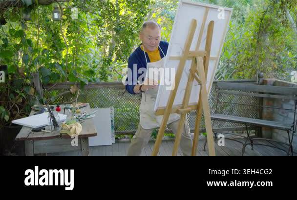 Senior Chinese man wearing apron inspired by garden deck selecting ...
