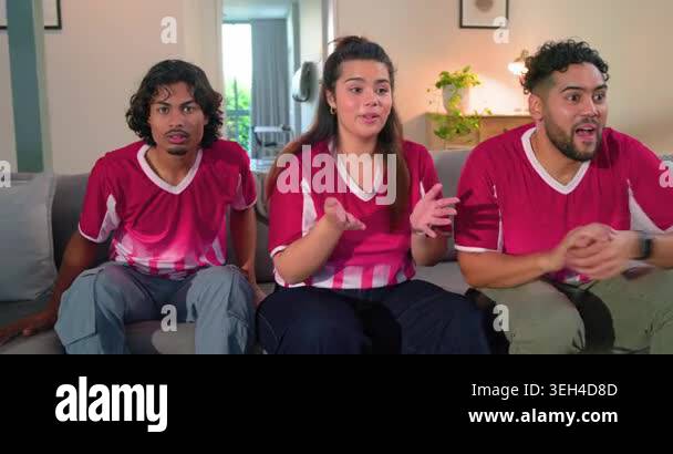 Diverse friends watching soccer match on TV from couch, gesturing ...