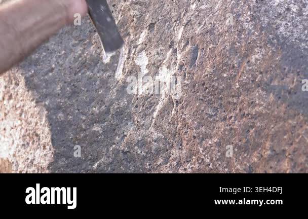 Prehistoric rock art carved by striking stone on surface, close detail ...