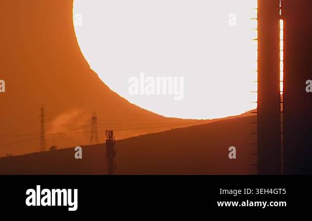 Extreme zoom construction sunrise timelapse with dark silhouettes ...