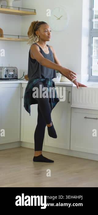 Vertical video: African American woman starting leg extensions in ...