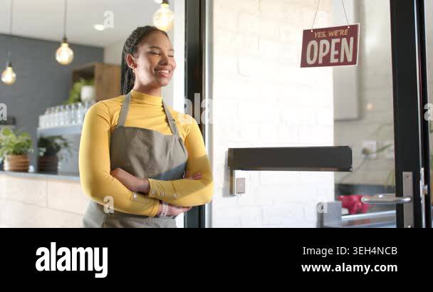 Seeing YES WE'RE OPEN sign woman wearing apron smiling and scanning for ...