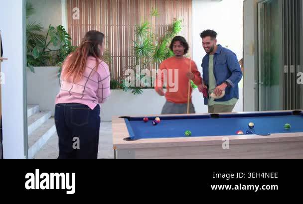 Diverse friends cheering, guiding woman arriving at patio pool table ...