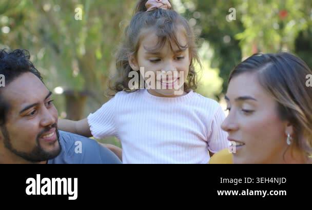 Parents leaning in as mother speaking, daughter laughing for fun ...
