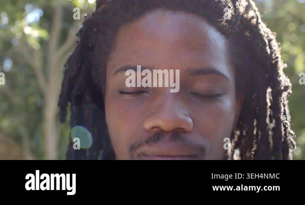 African American man 20s opening eyes, sunlight hitting, smiling ...