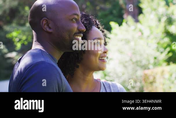 African American couple standing in garden spotting right, woman ...