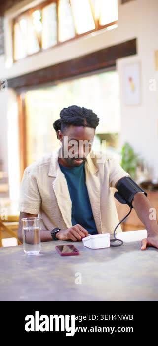 Vertical video: African man securing cuff, pressing monitor, monitoring ...