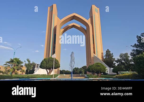 Yazd Quran Gate monument rises beside pool fountains at a symbolic city ...