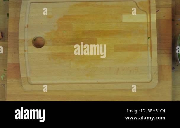 Woman slicing ripe avocado on a wooden cutting board during home ...