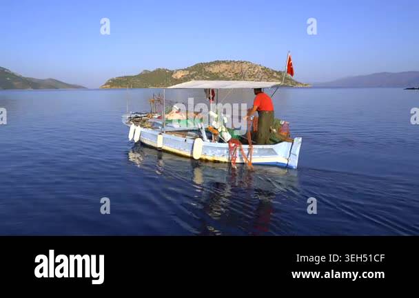 Turkish fisherman pulls a net by hand on an Aegean fishing boat with ...