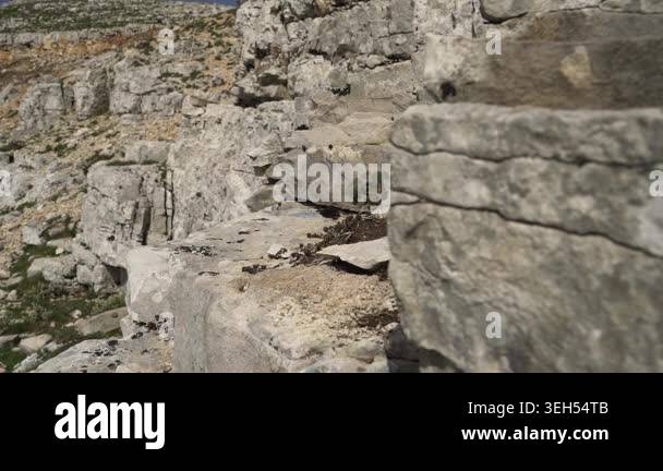 White gray limestone bedrock forms a stepped tectonic landscape with ...