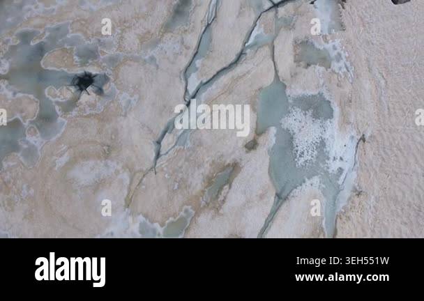 Snow and ice patterns cover a frozen river in high alpine winter ...
