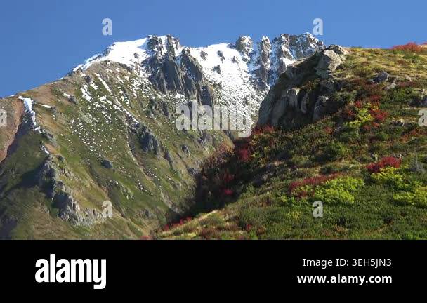 Snowy mountain summit dominates vast landscape, steep ridges and high ...