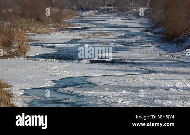 Frozen water surface holds ice sheets and cracks, winter stream river ...