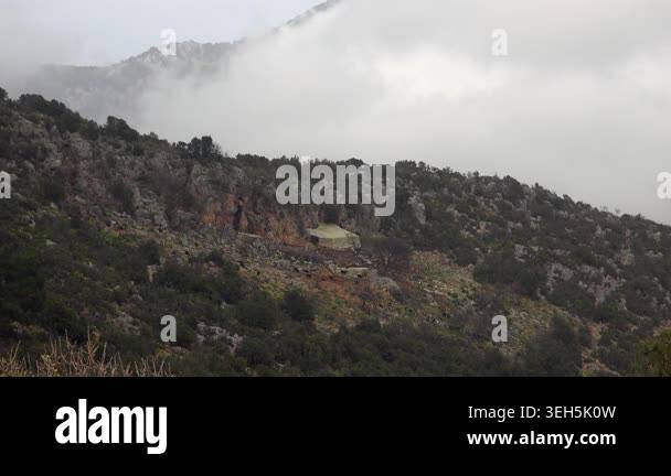 Goat pen and herd rest in the Taurus Mountains beneath cloudy weather ...
