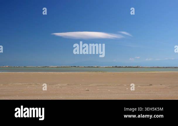 Single cirrus cloud drifts over beach and sea in a minimalist timelapse ...