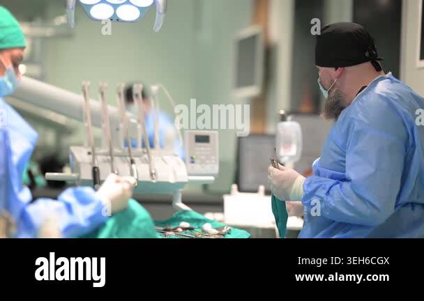 Dental surgeons and assistants wearing protective scrubs and masks ...
