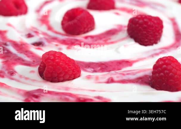 Juicy ripe raspberry on smooth white yogurt with soft texture and ...