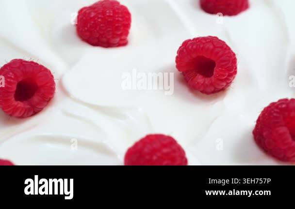 Juicy ripe raspberry on smooth white yogurt with soft texture and ...
