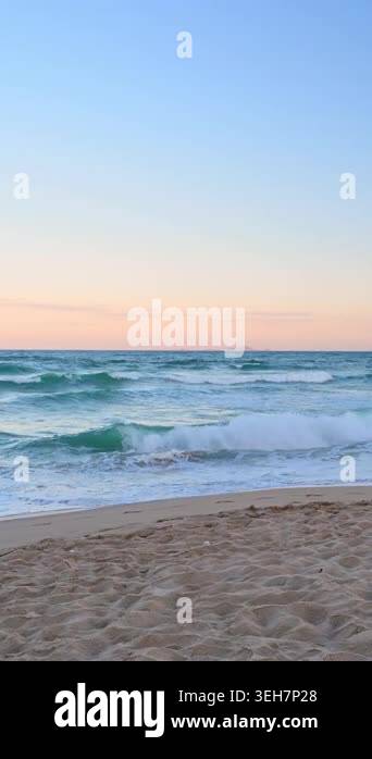 beautiful tropical seascape featuring rolling sea waves, pastel sunset ...