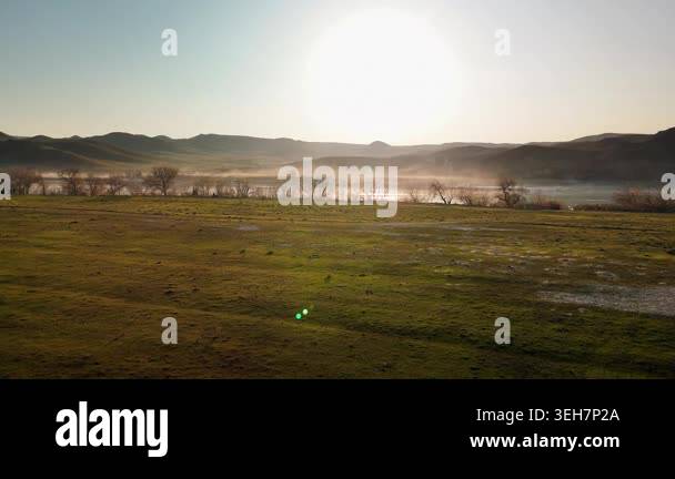 Aerial view Drone shot of river Ili and spring steppe at subset cloudy ...