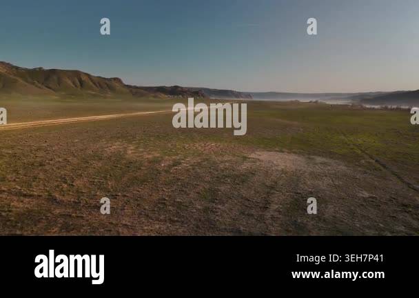 Aerial view Drone shot of river Ili and spring steppe at subset cloudy ...
