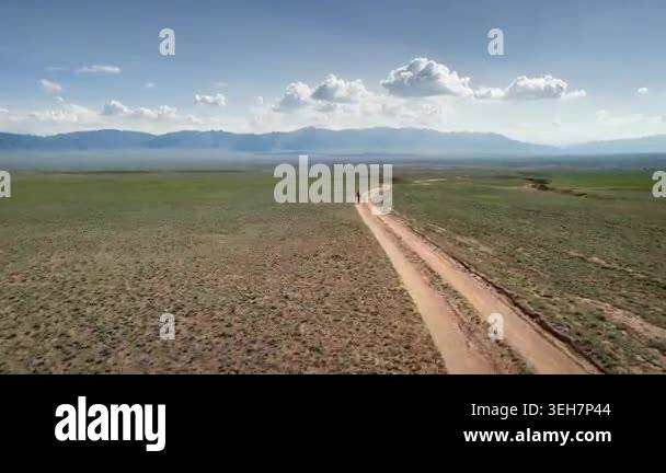 Aerial view Drone shot of mtb bike rider at dusty country road with ...