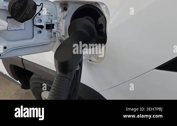 Close Up of Fuel Nozzle Inserted into White Vehicle During Refueling ...