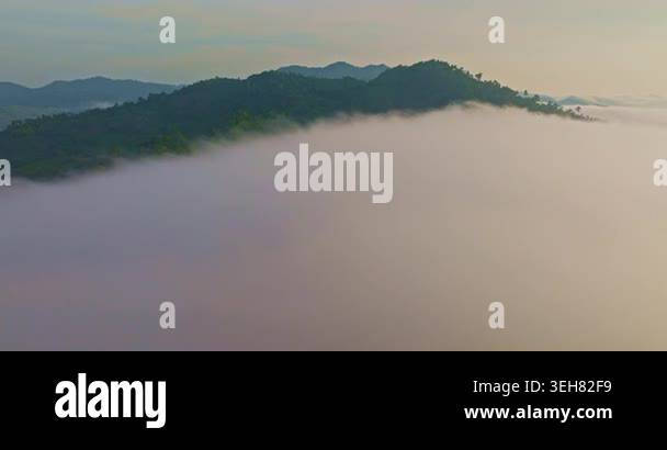 Landscape of mountains partially covered in fog during early morning ...
