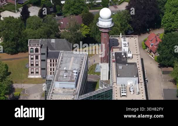 Aerial view orbiting a prominent weather radar station with a white ...