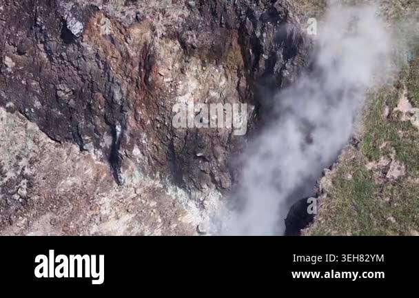 Top down aerial view of a natural fumarole releasing hot geothermal ...
