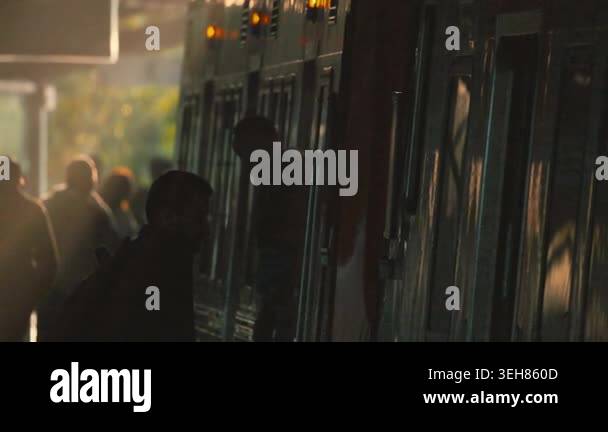 Many people move in and out of a train at a busy city station during ...