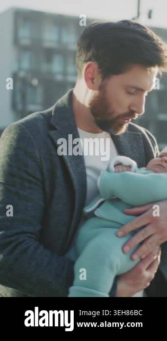 young white father holding baby close, soft morning light, urban ...